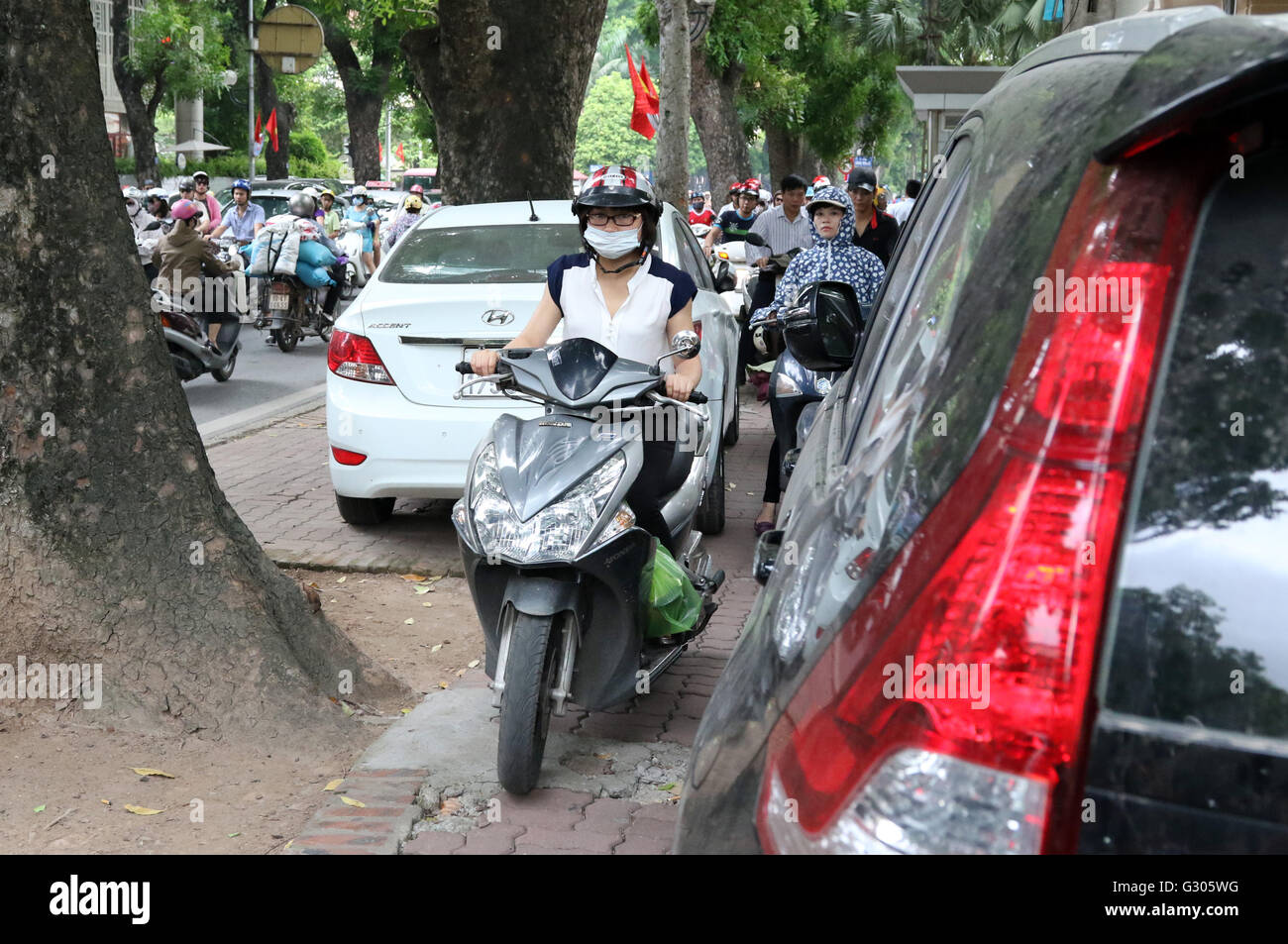 People riding scooters on pavement traffic jam Stock Photo - Alamy