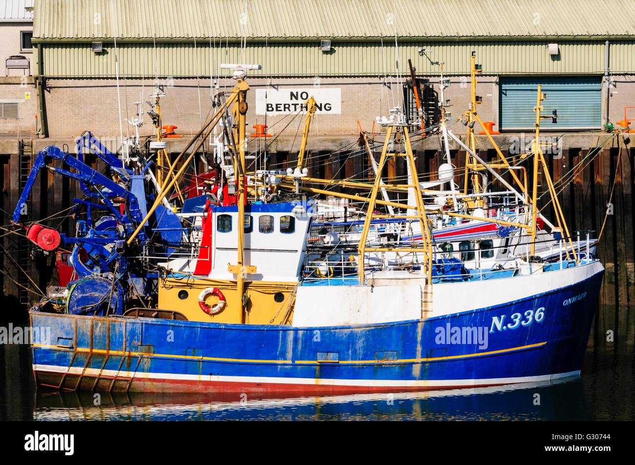 Trawlers berthed at a harbour sign saying "No Berthing Stock Photo - Alamy