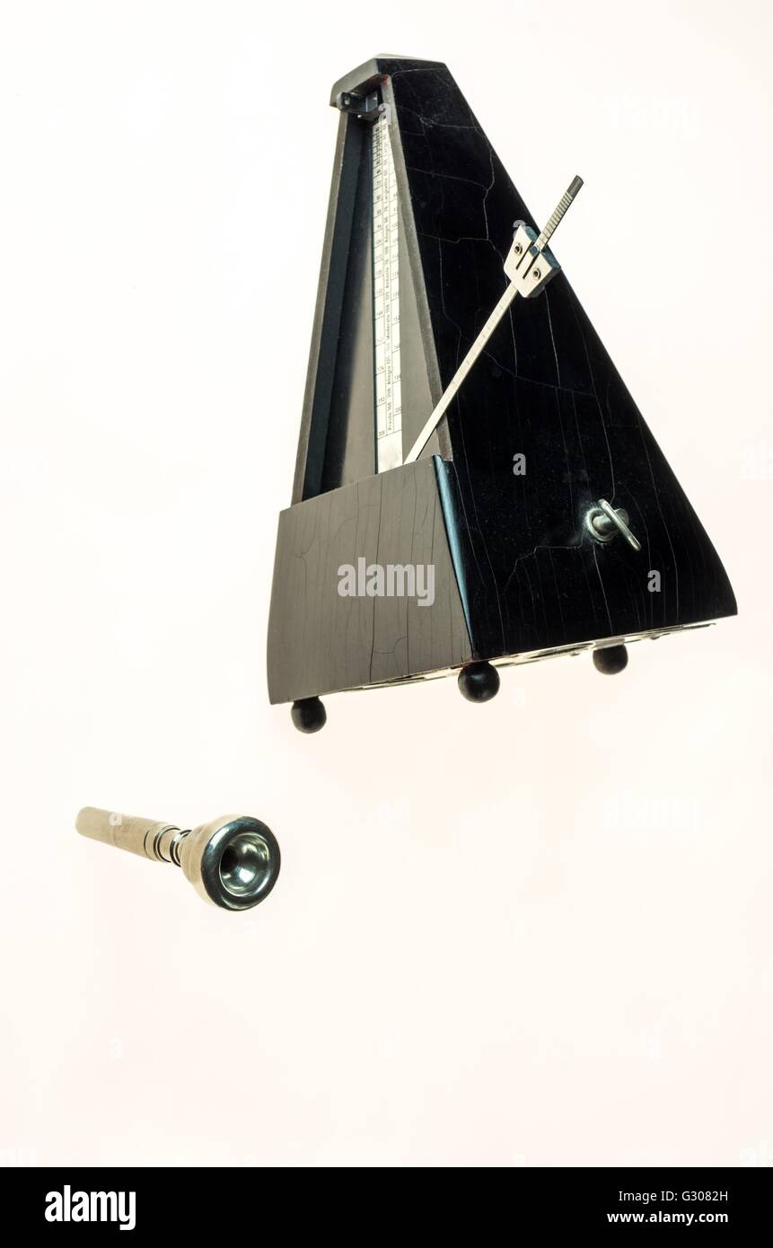 Metronome and mouthpiece of a trumpet isolated on a blank white ...