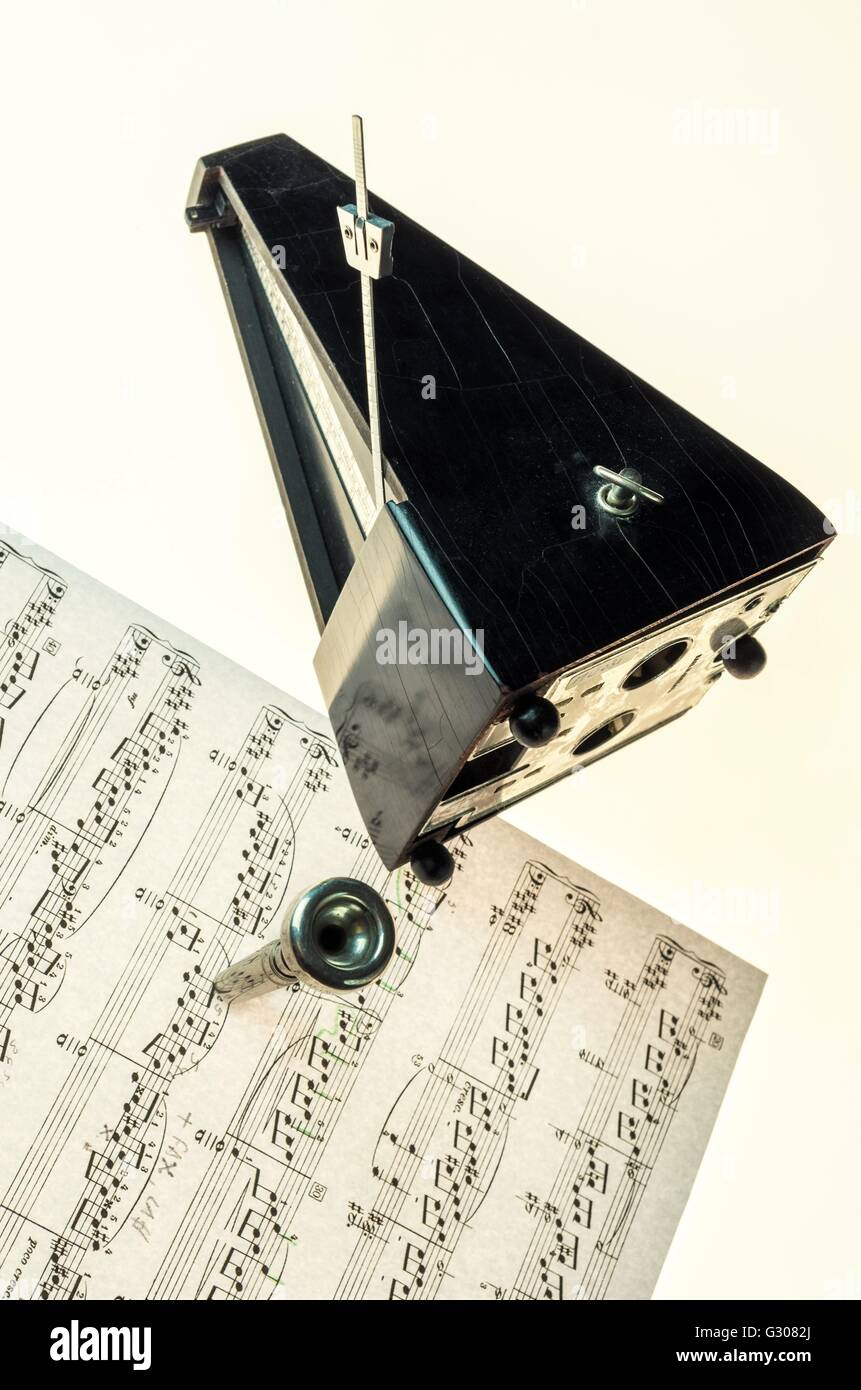 Metronome and mouthpiece of a trumpet isolated on a blank white ...