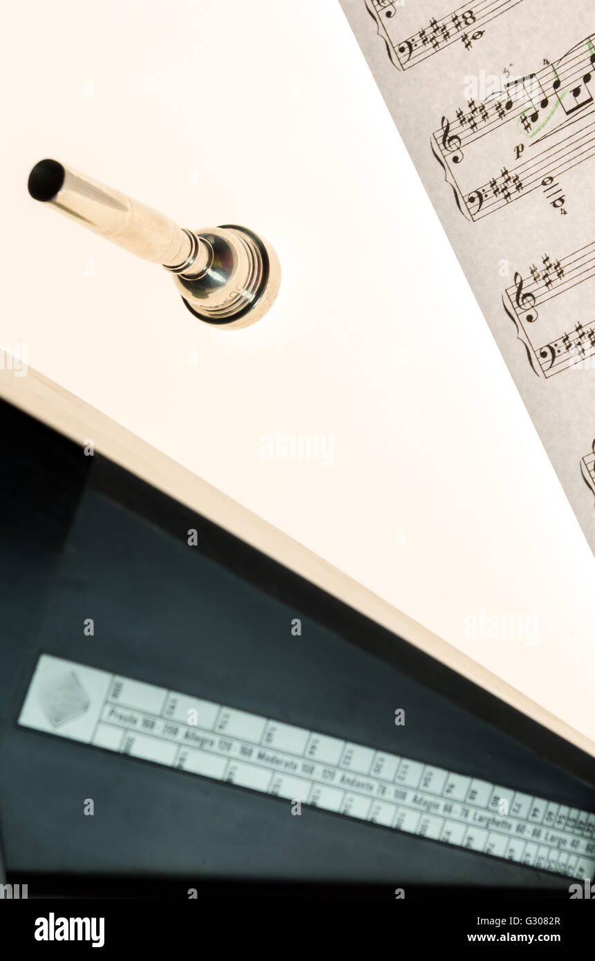 Metronome and mouthpiece of a trumpet isolated on a blank white ...