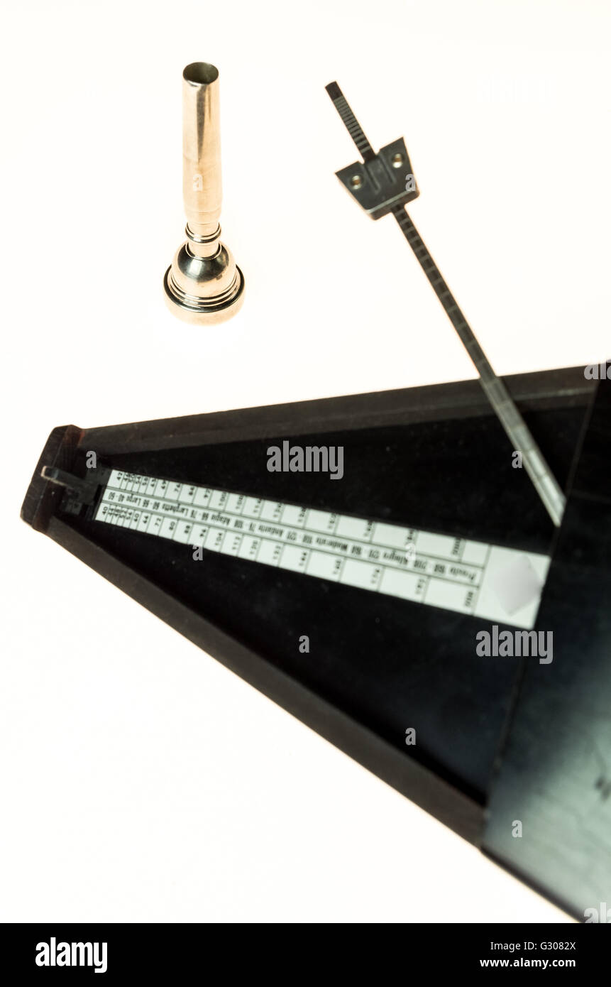Metronome and mouthpiece of a trumpet isolated on a blank white ...