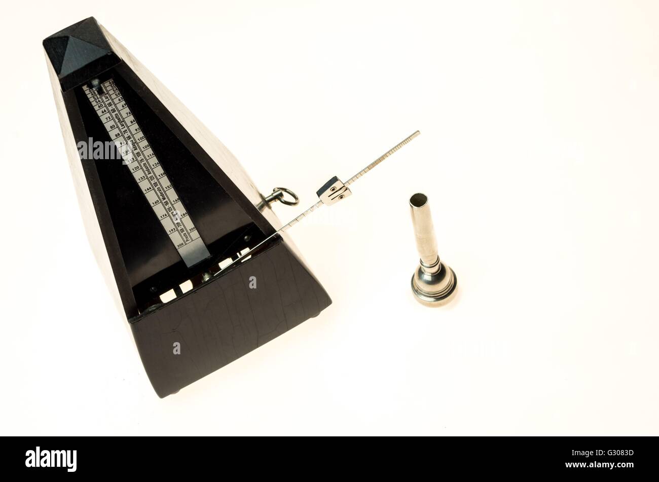 Metronome and mouthpiece of a trumpet isolated on a blank white ...