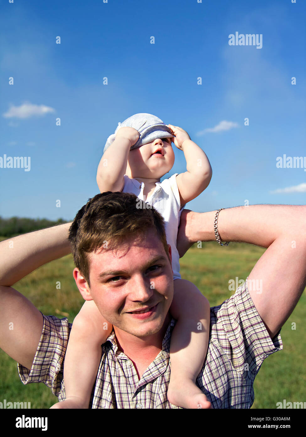 father holds a small child on his shoulders Stock Photo - Alamy