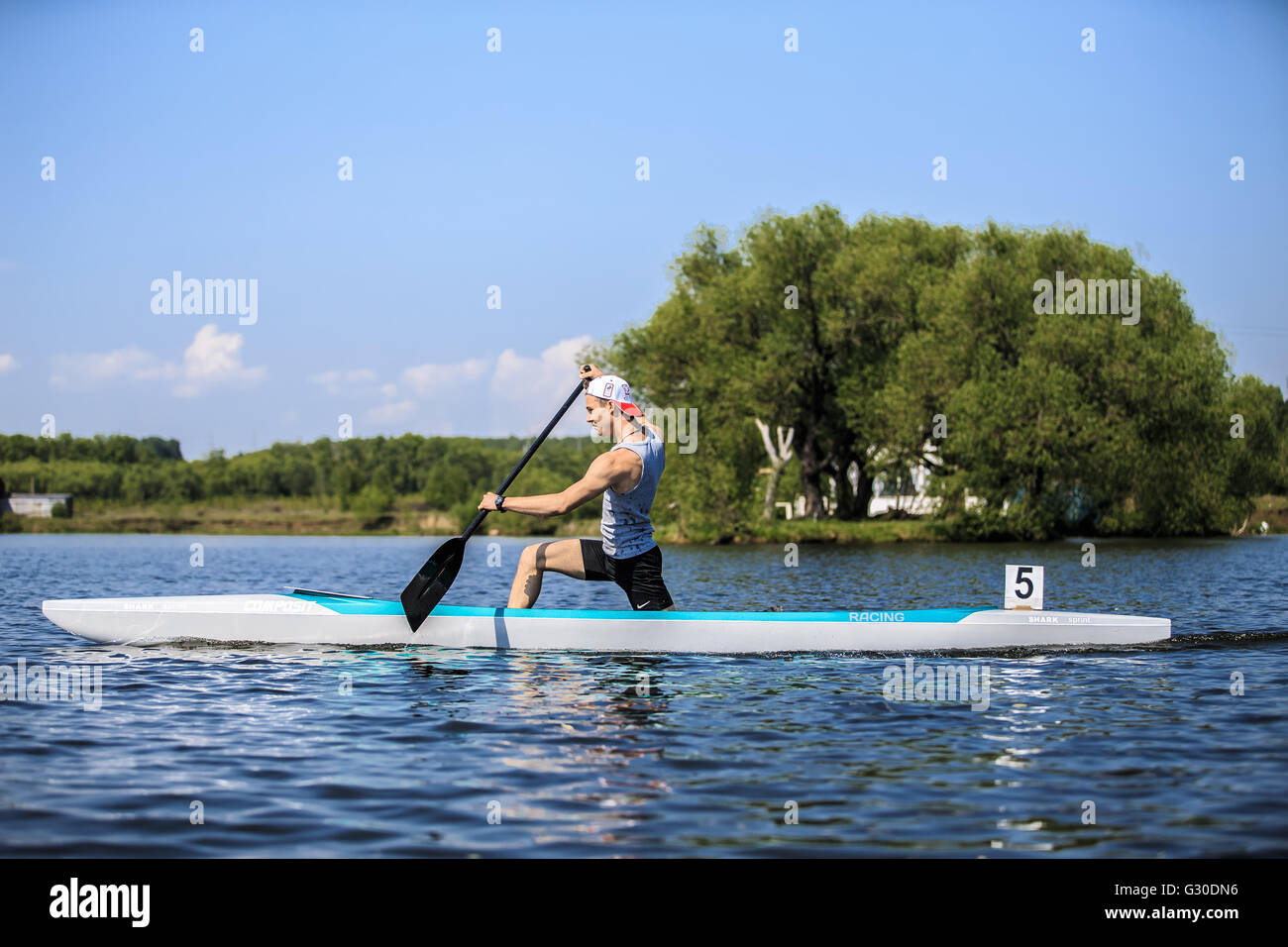 muscular male athlete in a canoe rowing during Ural championship in ...