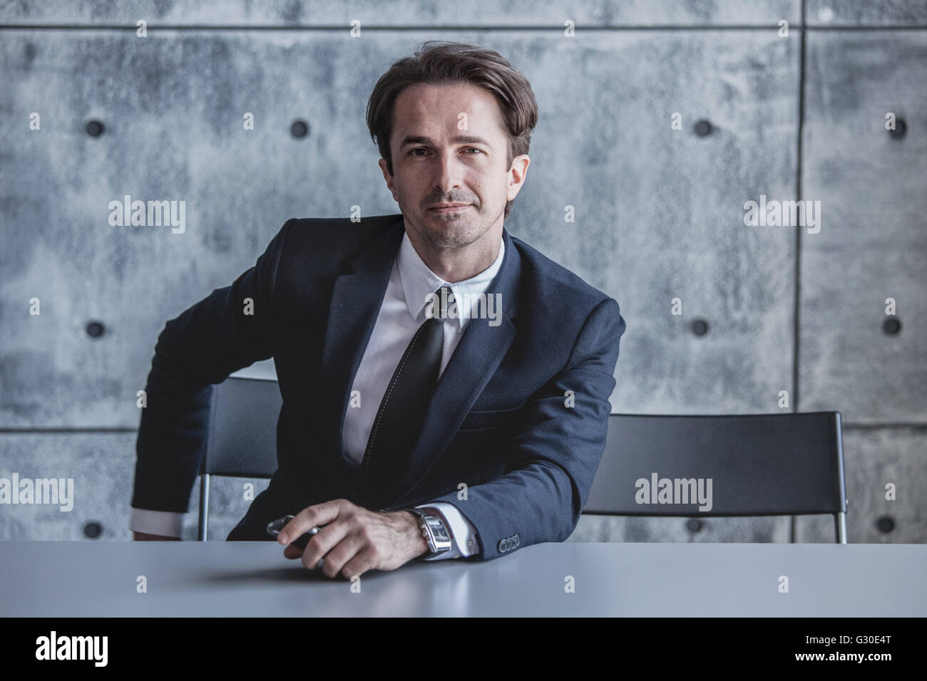 Man suit sitting behind table hi-res stock photography and images - Alamy