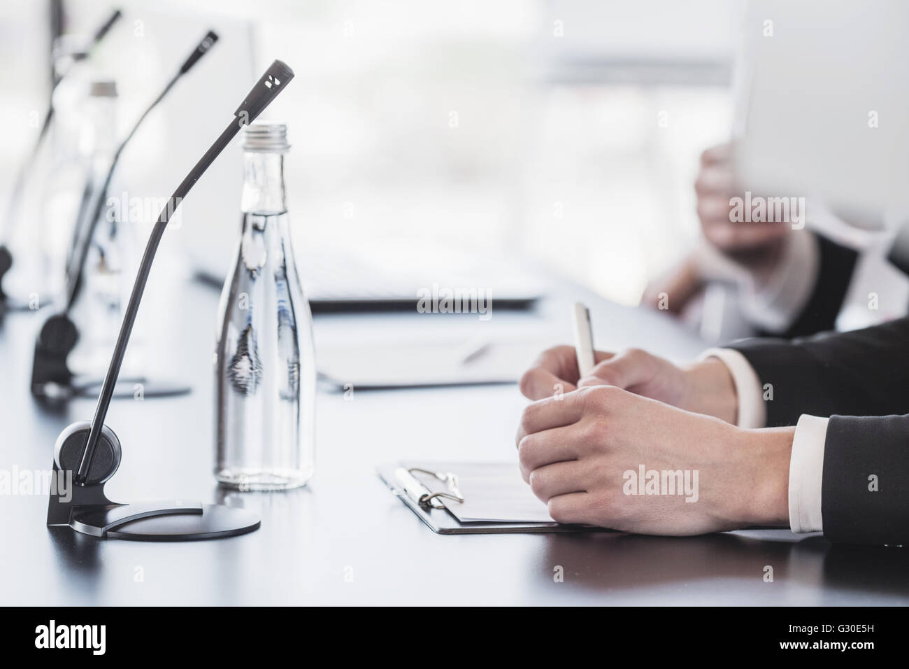 Microphones on table in conference room and business man hands Stock ...