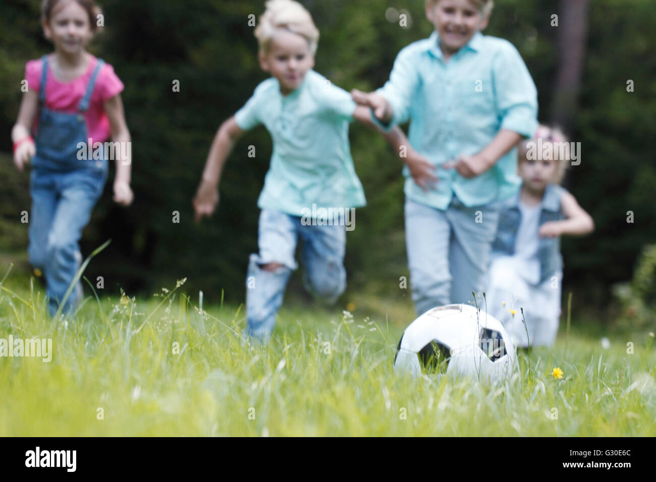 Happy children playing football in summer park Stock Photo - Alamy
