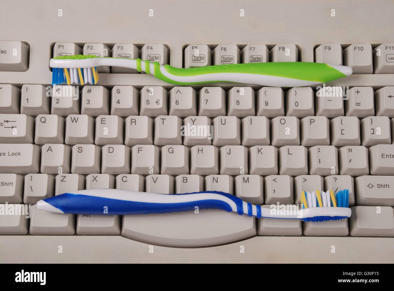 One computer keyboard and toothbrushes. Gray color Stock Photo - Alamy