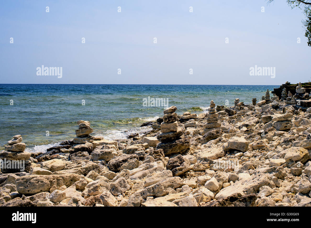 Lot of rocks stacked on top of each other along a a waterfront Stock ...