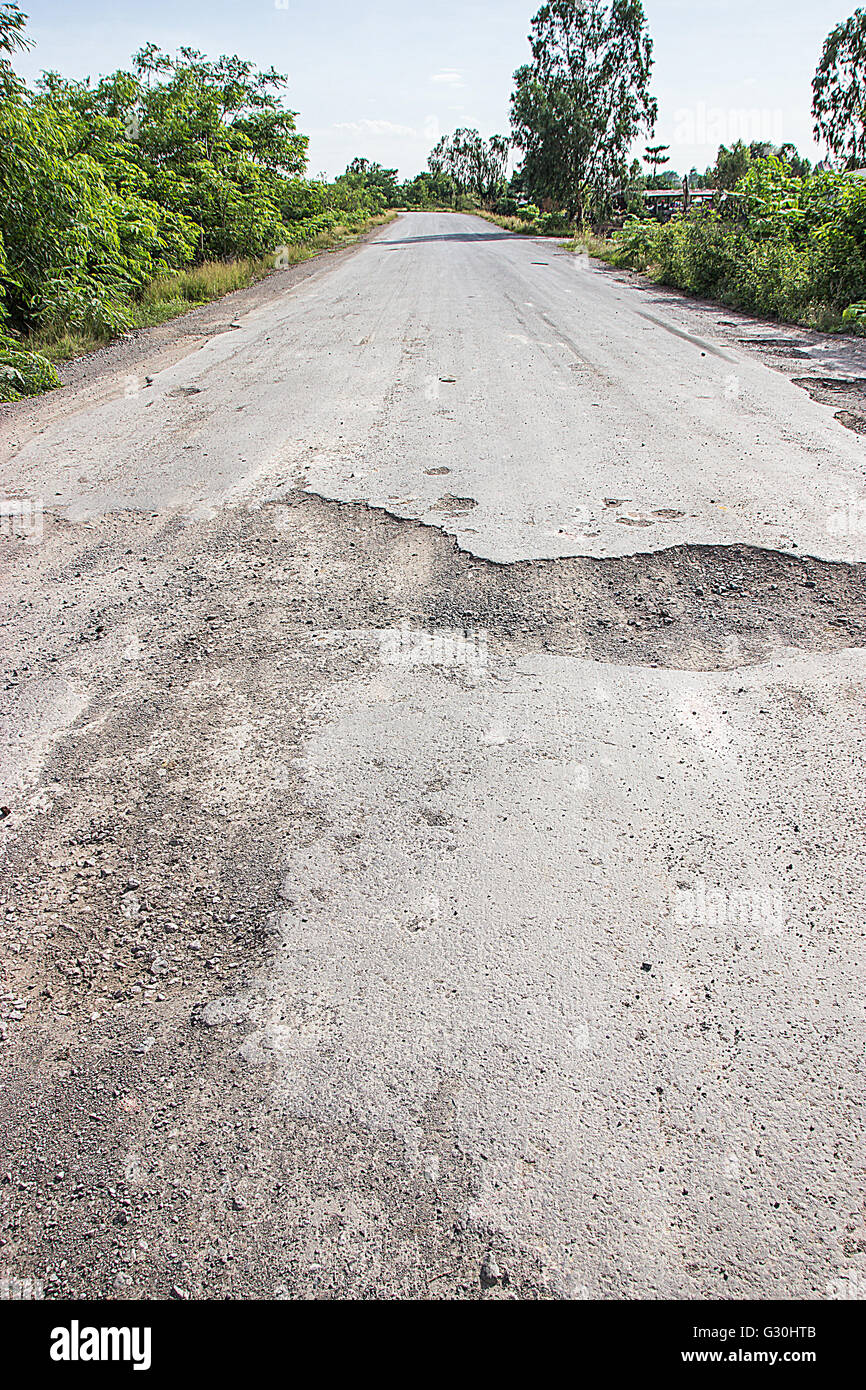 Damaged road in the countryside, damaged asphalt road with potholes ...