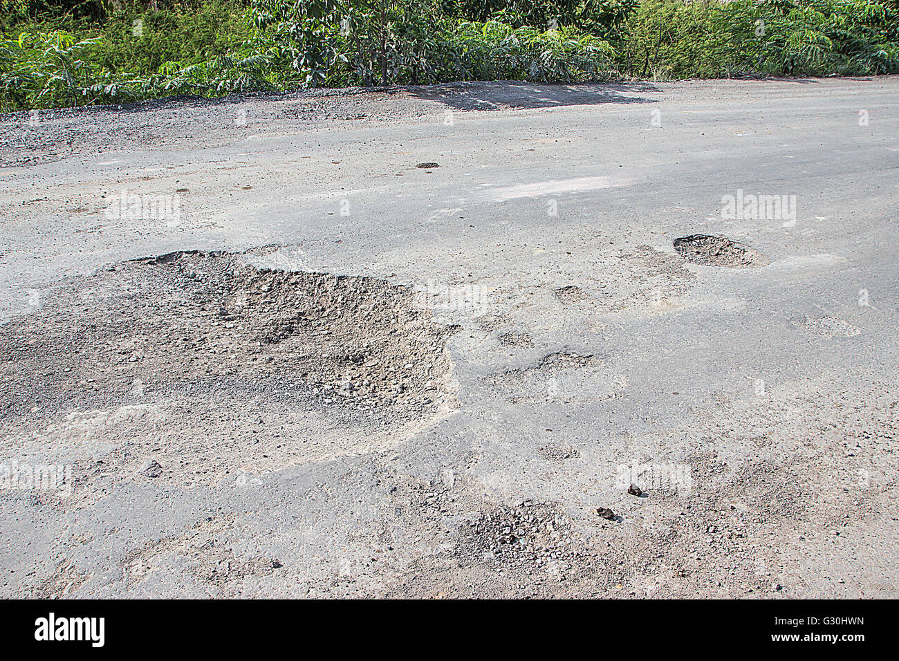 Damaged road in the countryside, damaged asphalt road with potholes ...