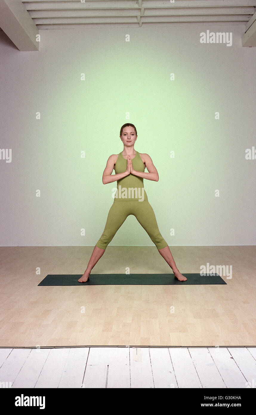 Stay Young, Warrior, woman standing on green mat, facing forward, feet ...