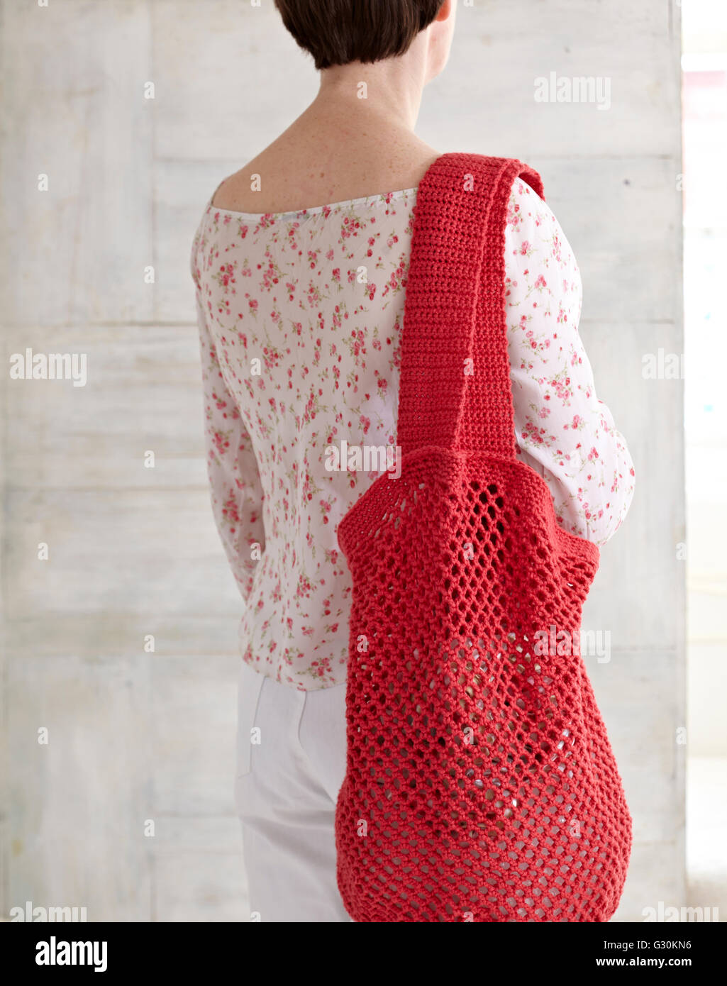 Woman with crocheted shopping bag over her shoulder Stock Photo - Alamy