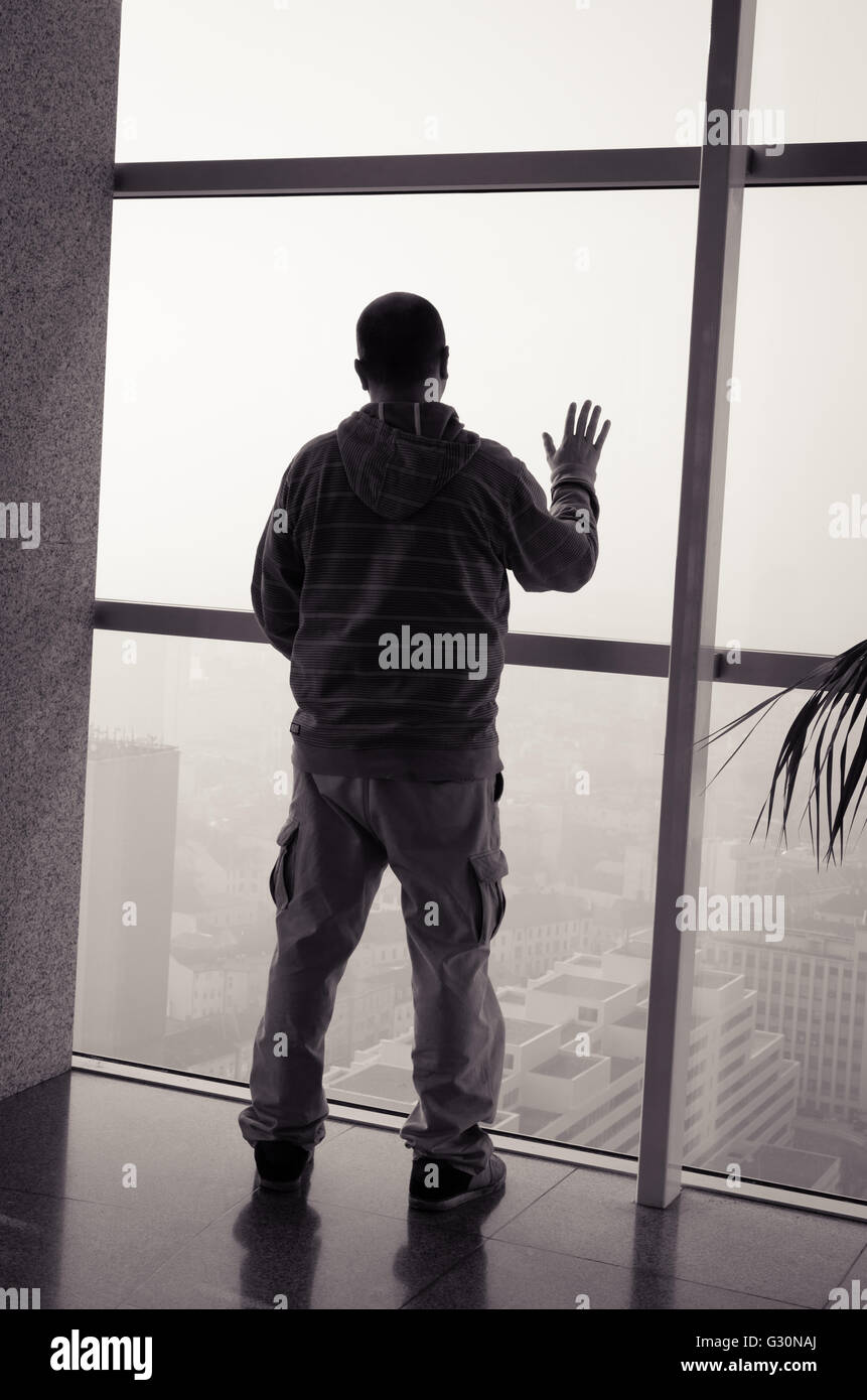 man touching window in high building Stock Photo - Alamy