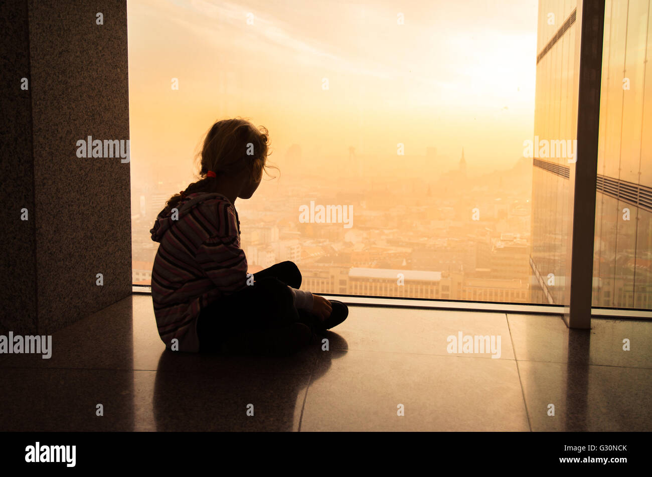 little child looking through a window to the city Stock Photo - Alamy