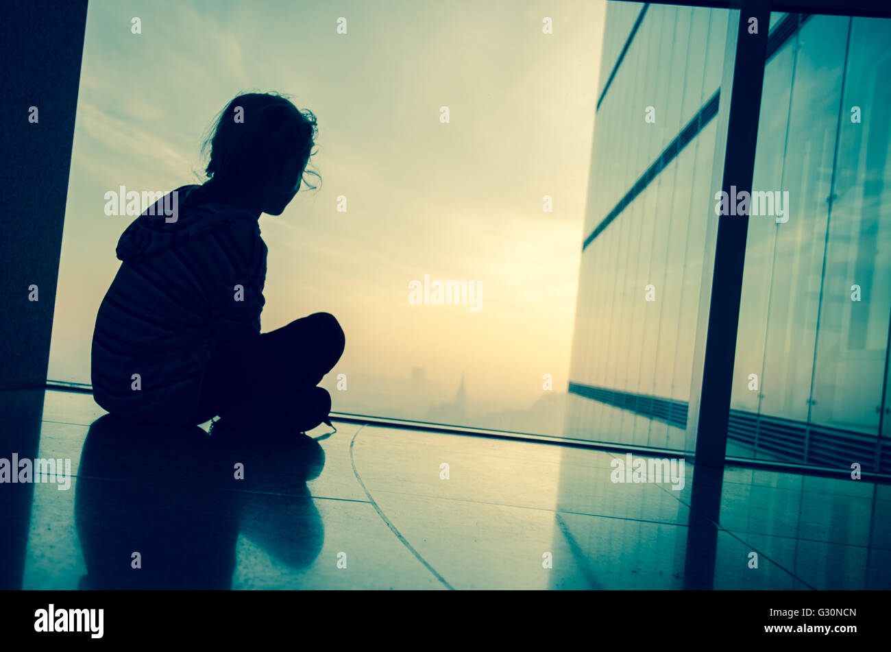 little child looking through a window to the city Stock Photo - Alamy