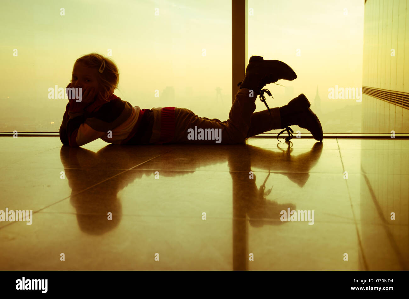 little child lying at the window to the city Stock Photo - Alamy