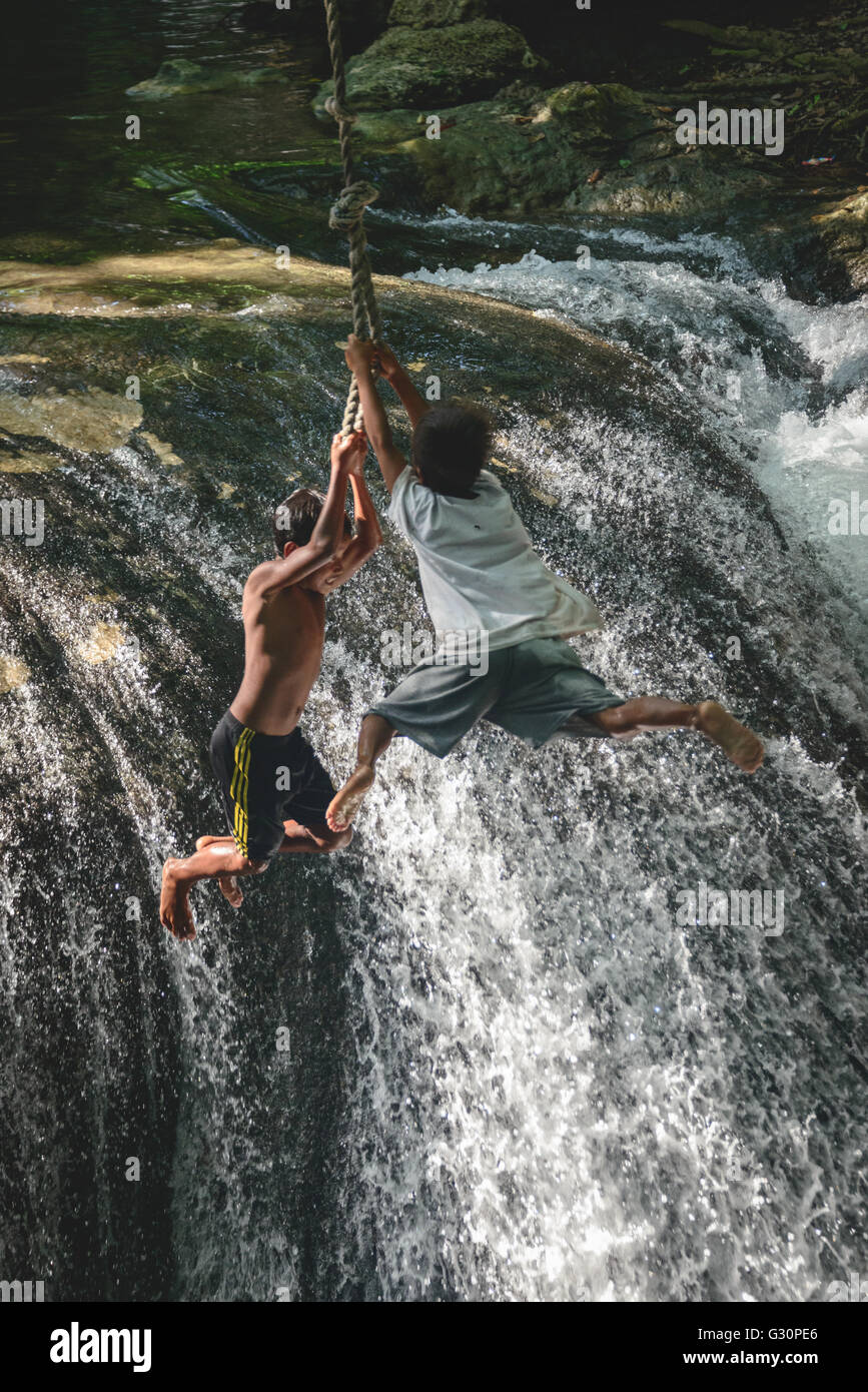 Local kids playing at a waterfall in Moyo Island Stock Photo - Alamy