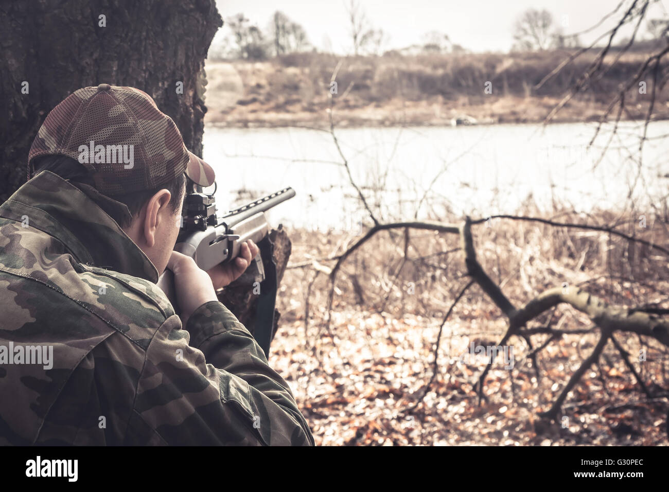 Hunter man with gun aiming and prepared to make a shot during hunt ...