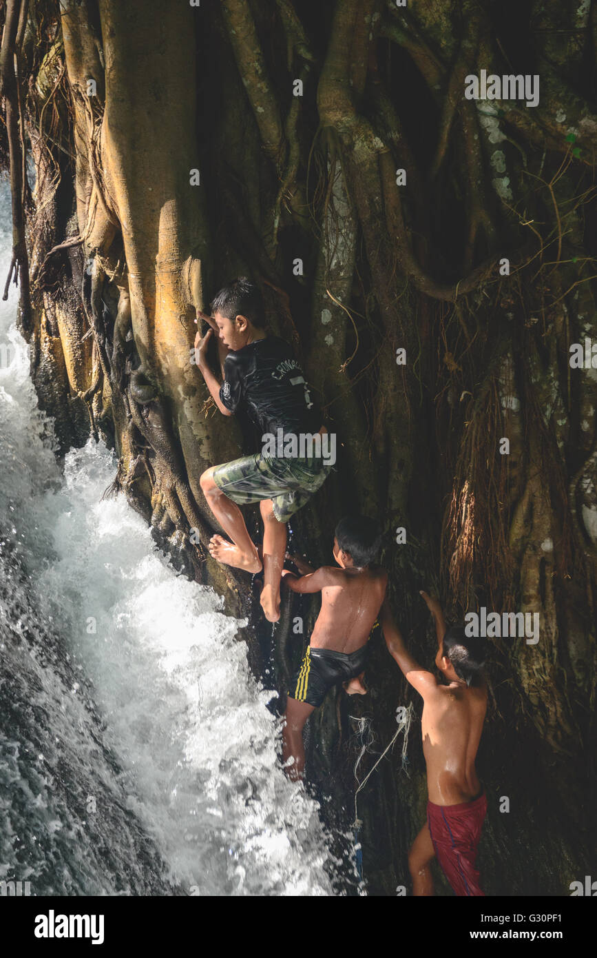 Local kids playing at a waterfall in Moyo Island Stock Photo - Alamy
