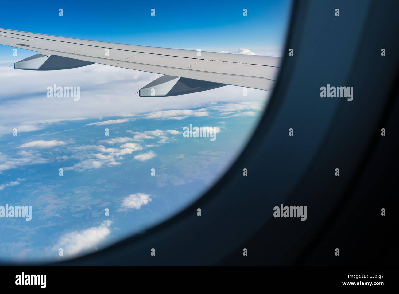 VIEW THROUGH A WINDOW OF A PASSENGER AIRCRAFT WITH THE WING IN VIEW AND ...