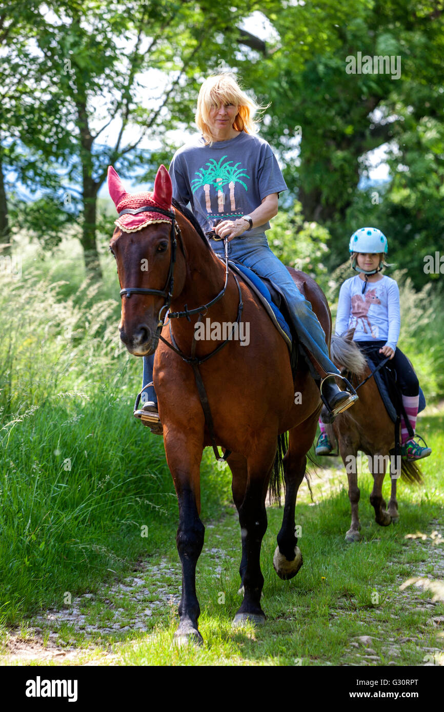 People horseback riding summer path, trekking child with woman ON ...