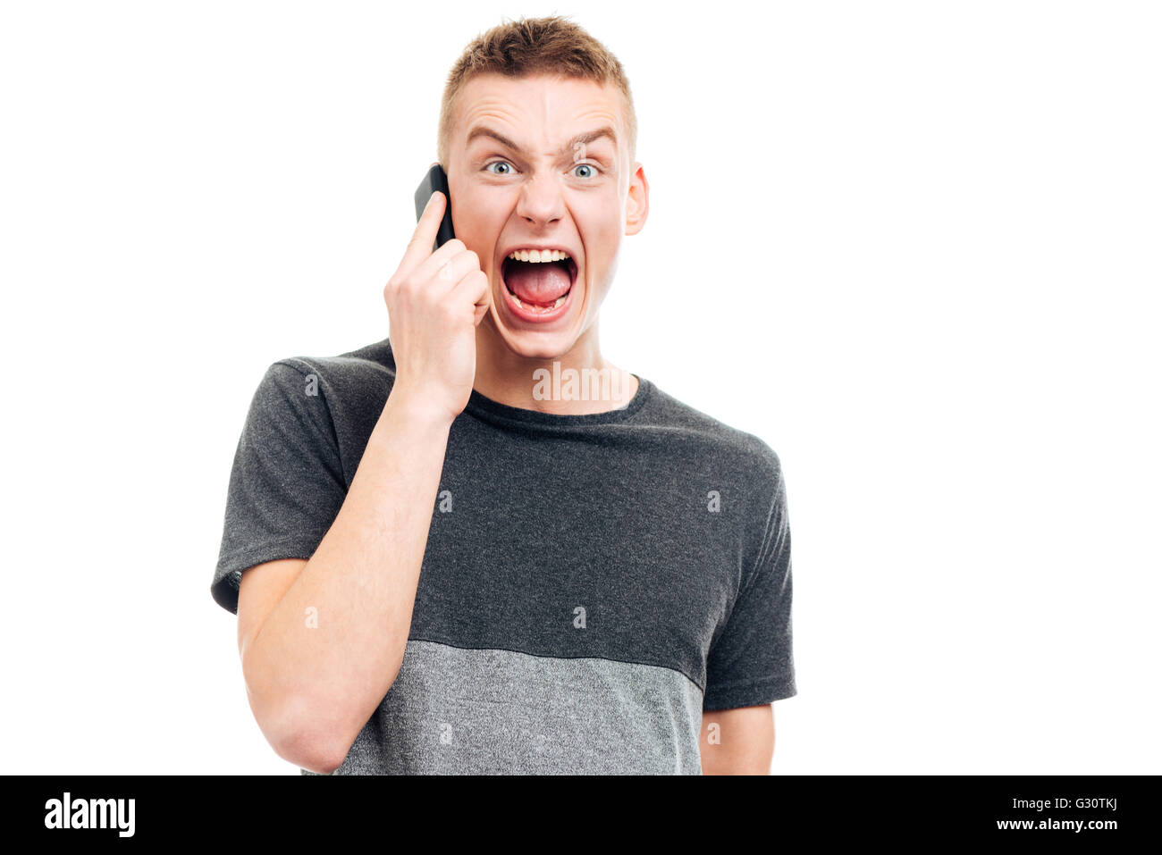 Angry casual man talking on the phone isolated on a white background ...