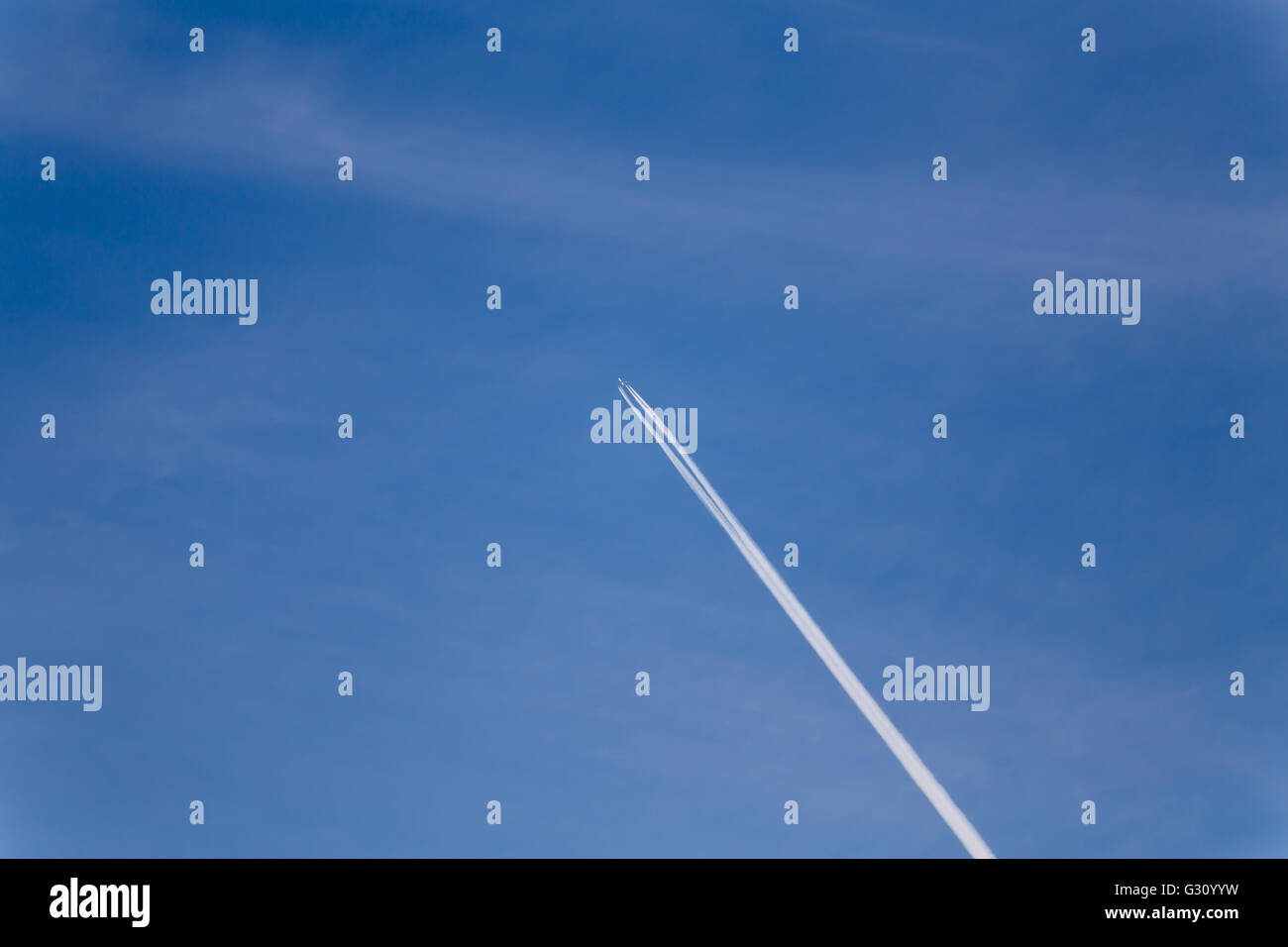 Shot of long trail of jet plane on blue sky Stock Photo - Alamy