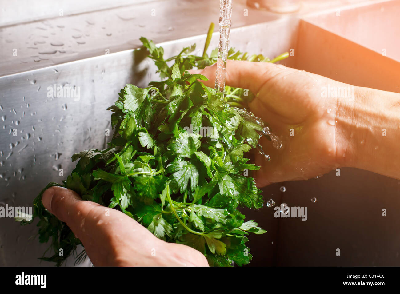 Man's hands washing parsley Stock Photo - Alamy