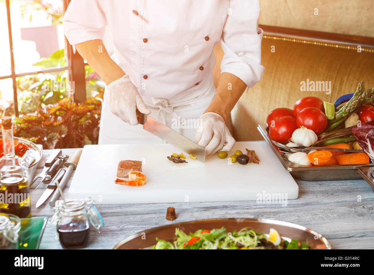 Hand with knife slicing olive Stock Photo - Alamy