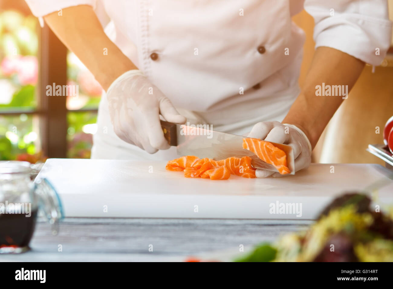 Hand with knife cutting fish Stock Photo - Alamy