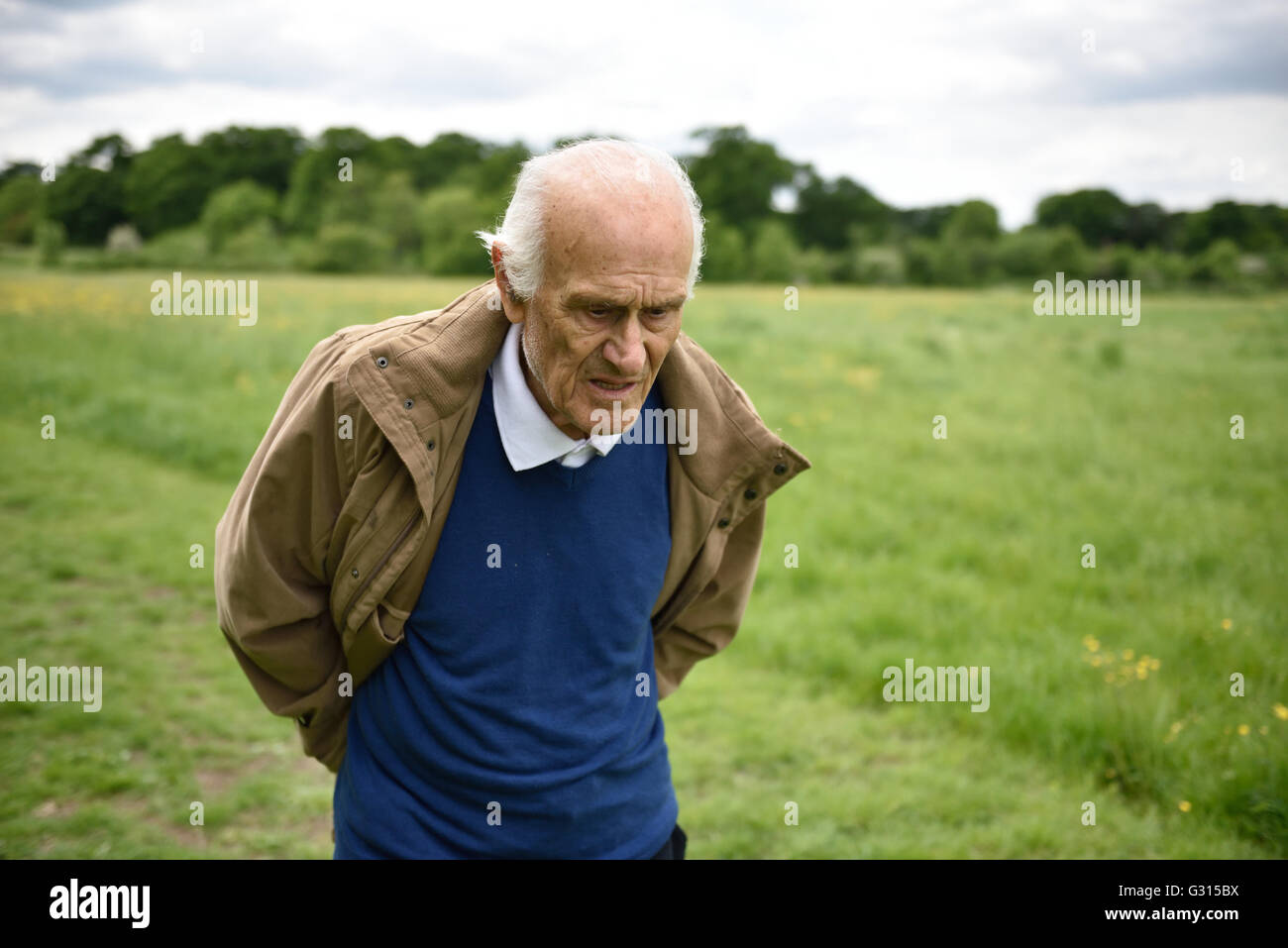 An elderly man with dementia looking thoughtful, walking on his own in ...