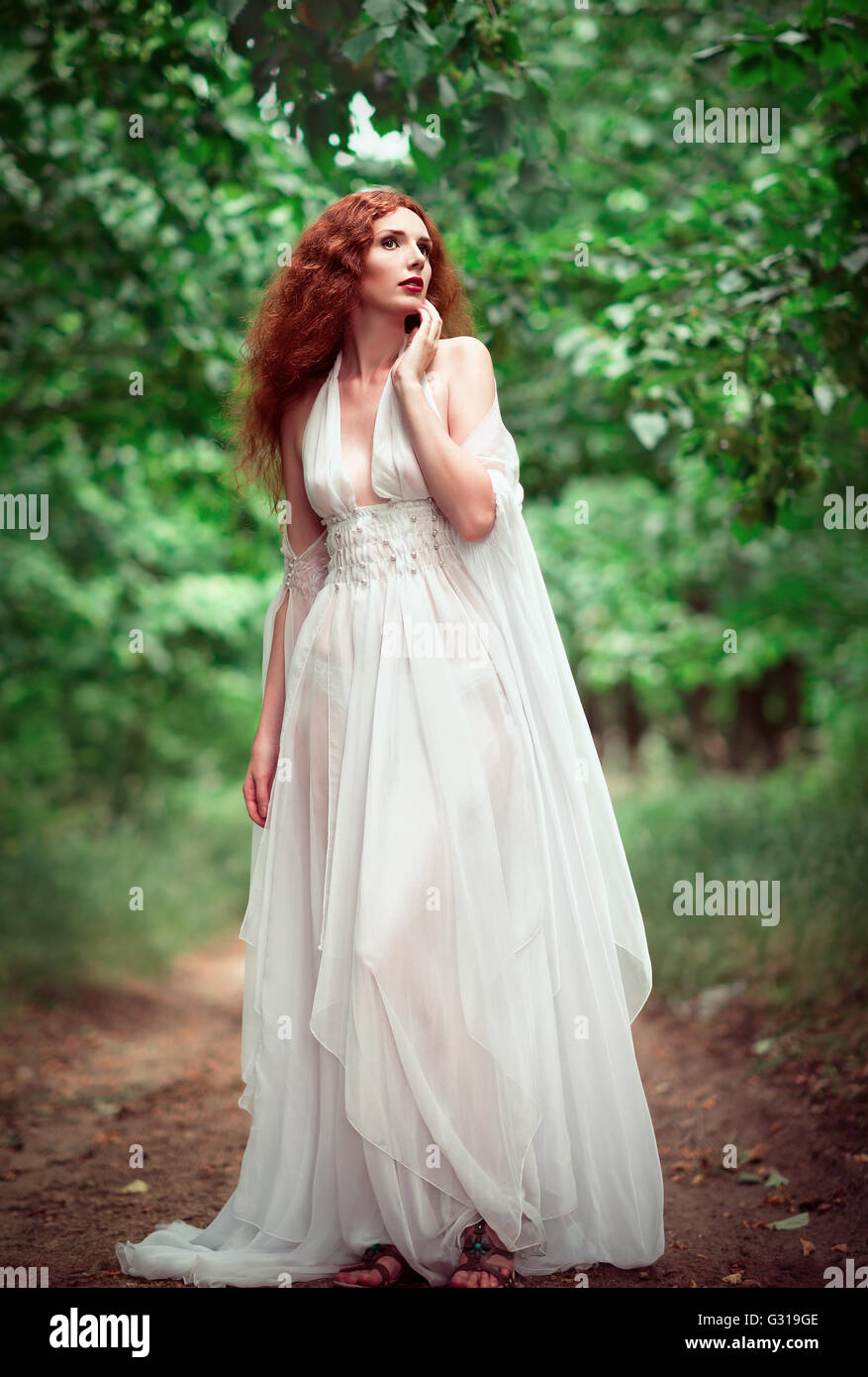 Beautiful ginger woman wearing white dress in the grove Stock Photo - Alamy