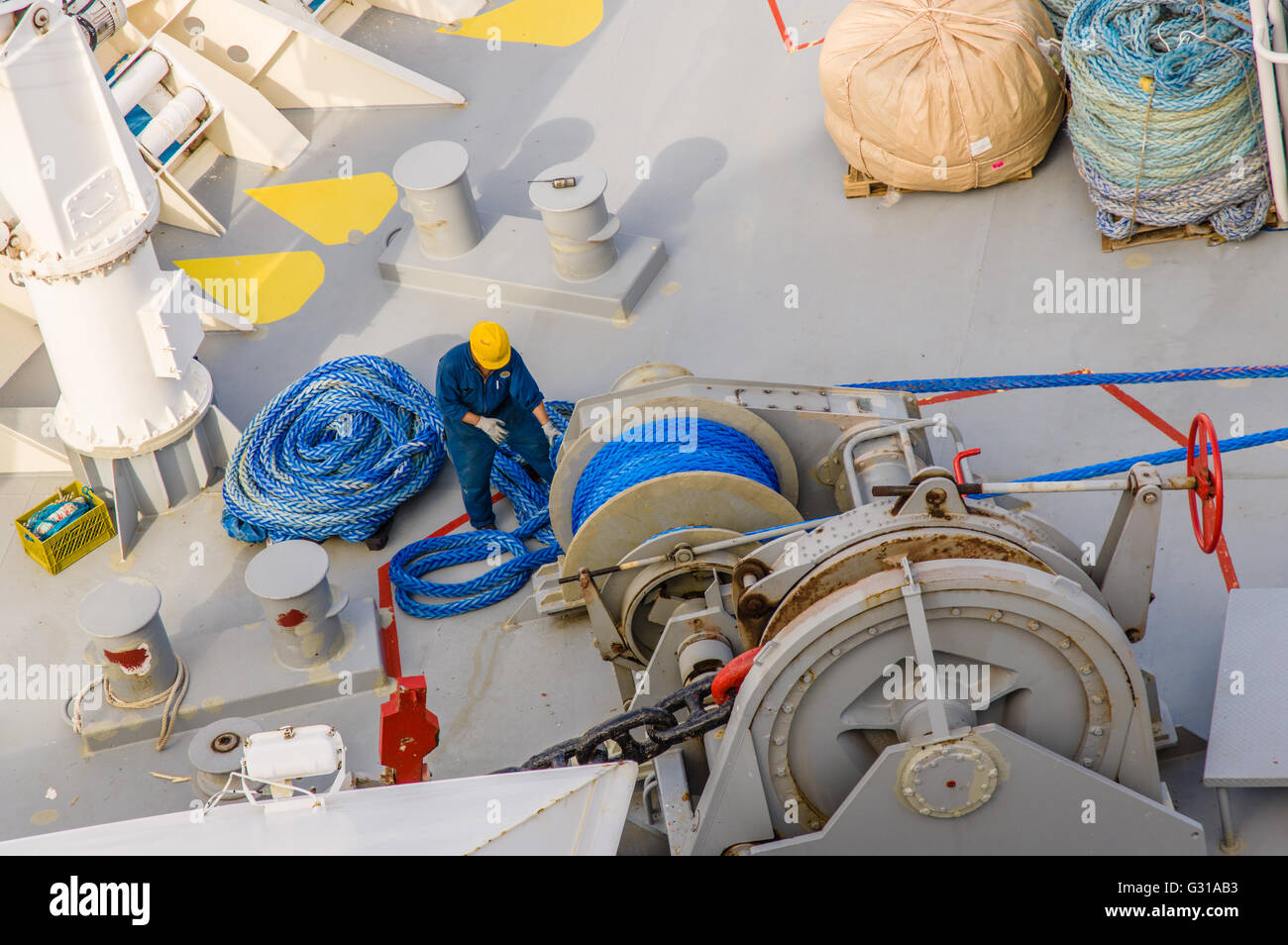 Crew members pull in the ropes securing cruise ship Vision of the Seas ...