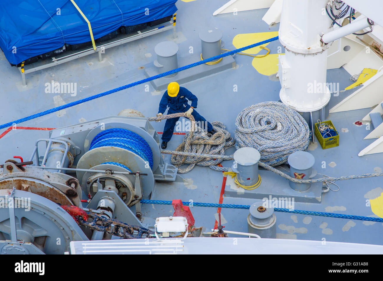 Crew members pull in the ropes securing cruise ship Vision of the Seas ...