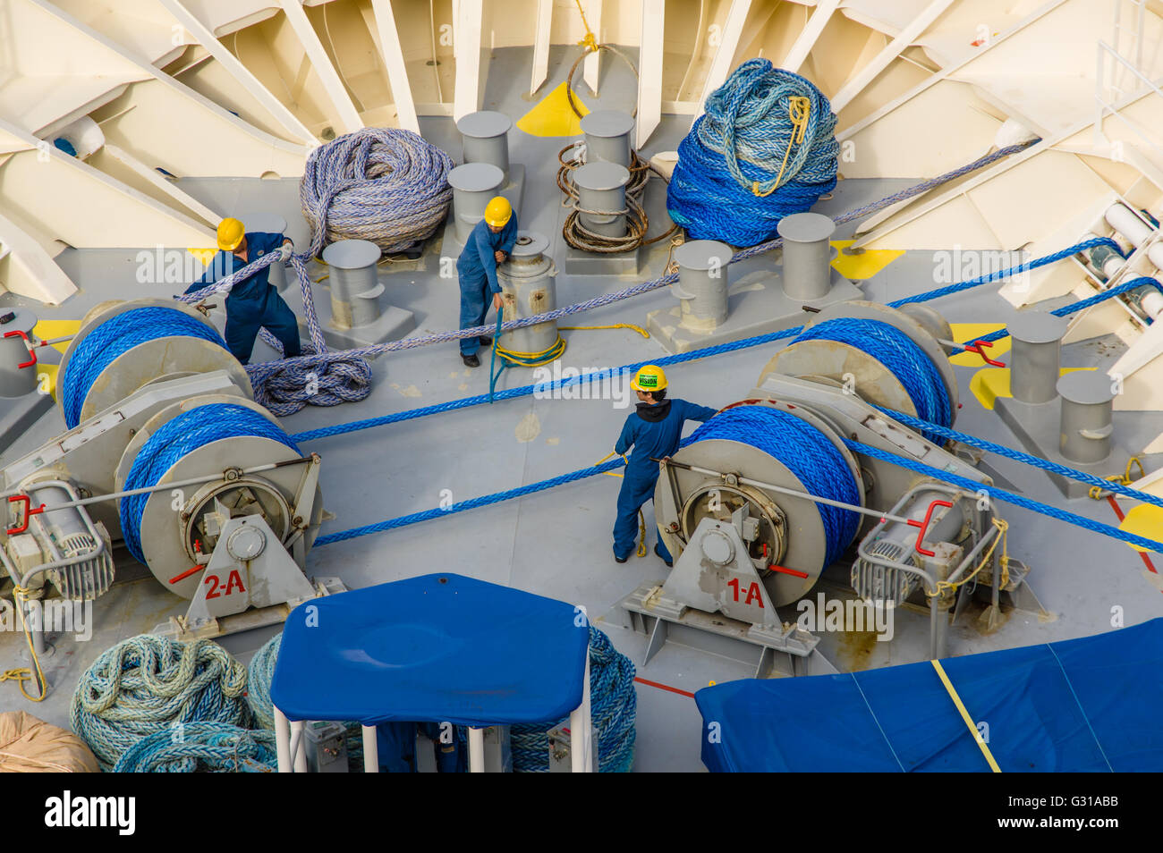 Crew members pull in the ropes securing cruise ship Vision of the Seas ...