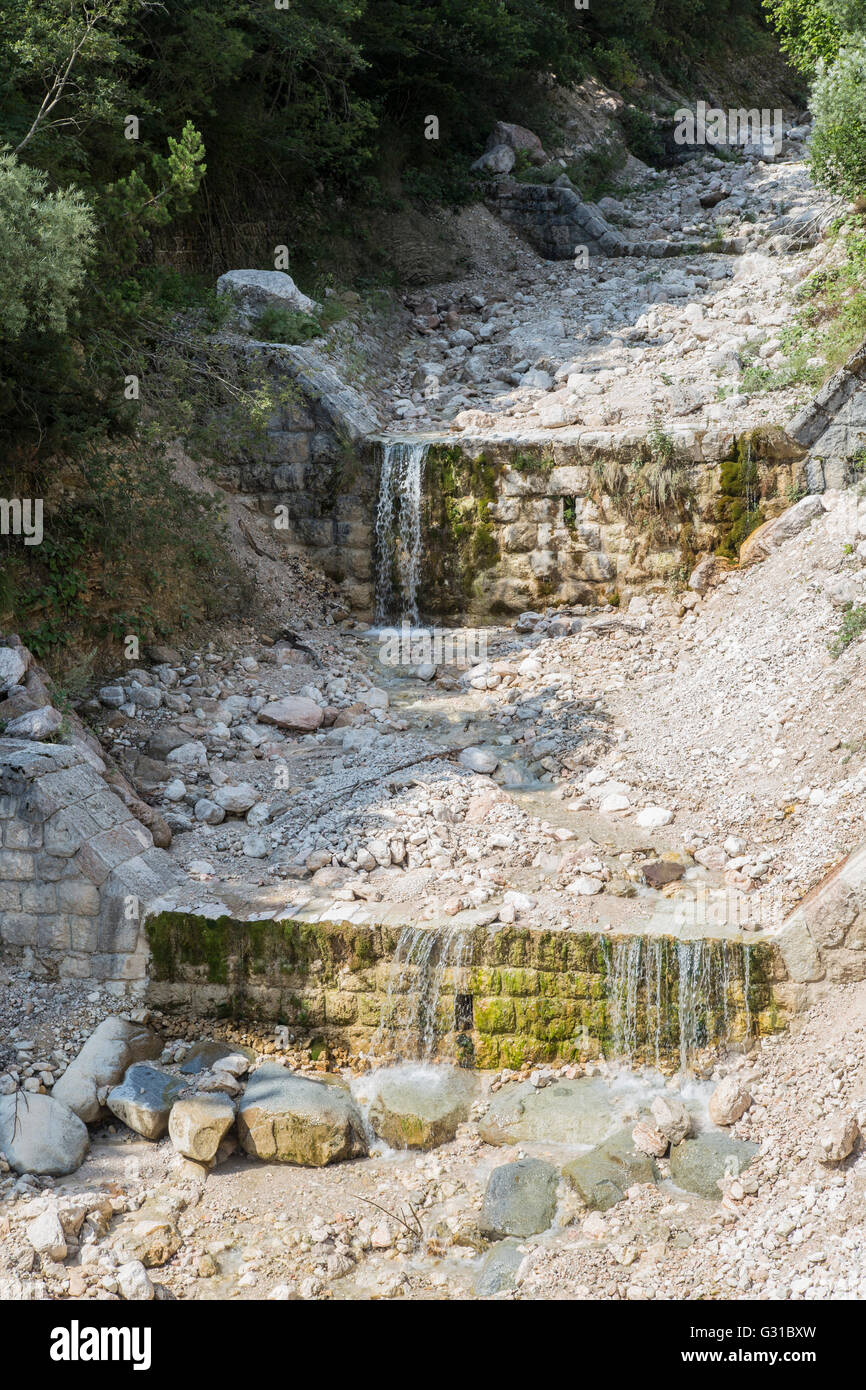 View on small stone walls creating waterfalls along a stream Stock ...