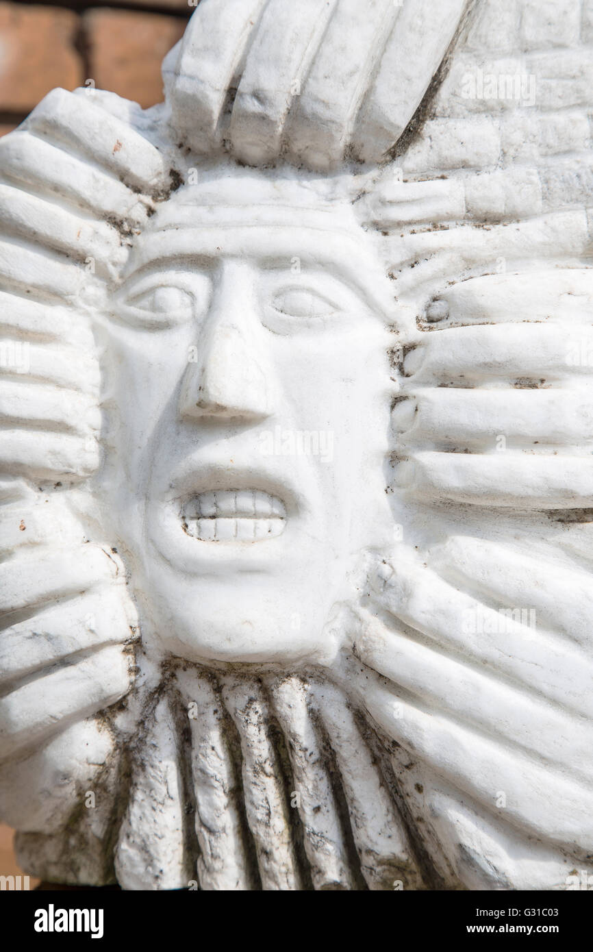 Close-up of the carved face of a man with gritted teeth in a white wall ...