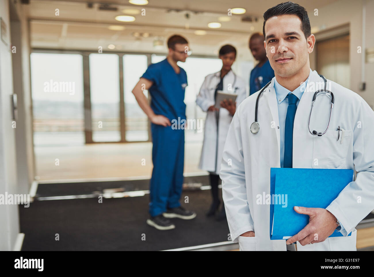 Doctor at hospital standing in front of team of surgeons and doctors ...