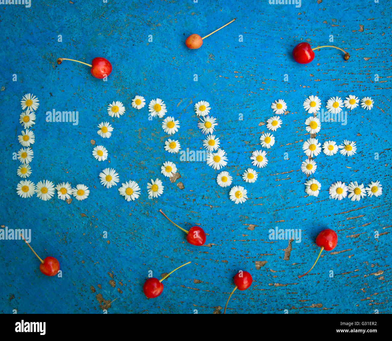 The word Love written of daisy flowers on textured blue background, top ...
