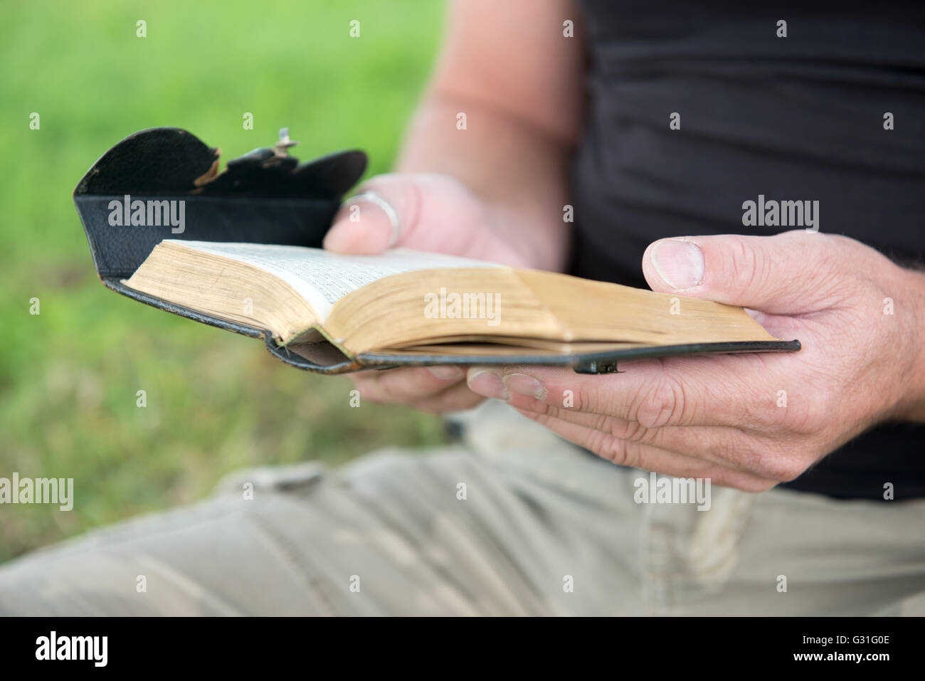 Man reading a bible outside Stock Photo - Alamy