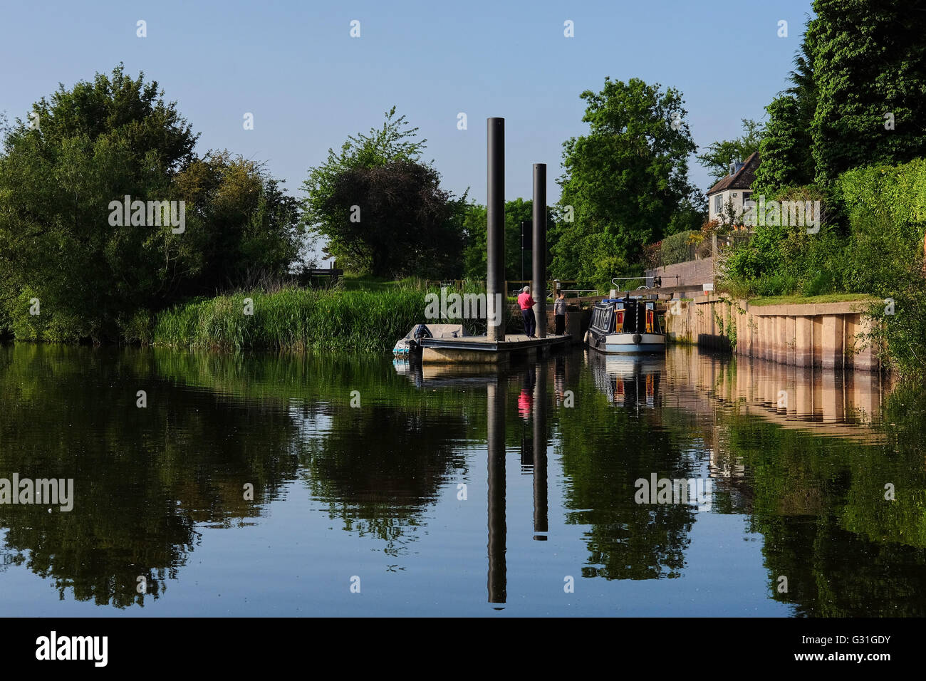 A canal barge enters the Droitwich canal through a lock from the river ...
