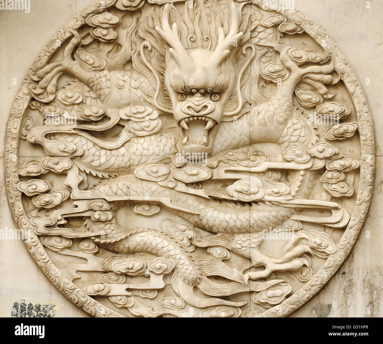 A carved Chinese dragon out of stone on a wall within Harbin China ...
