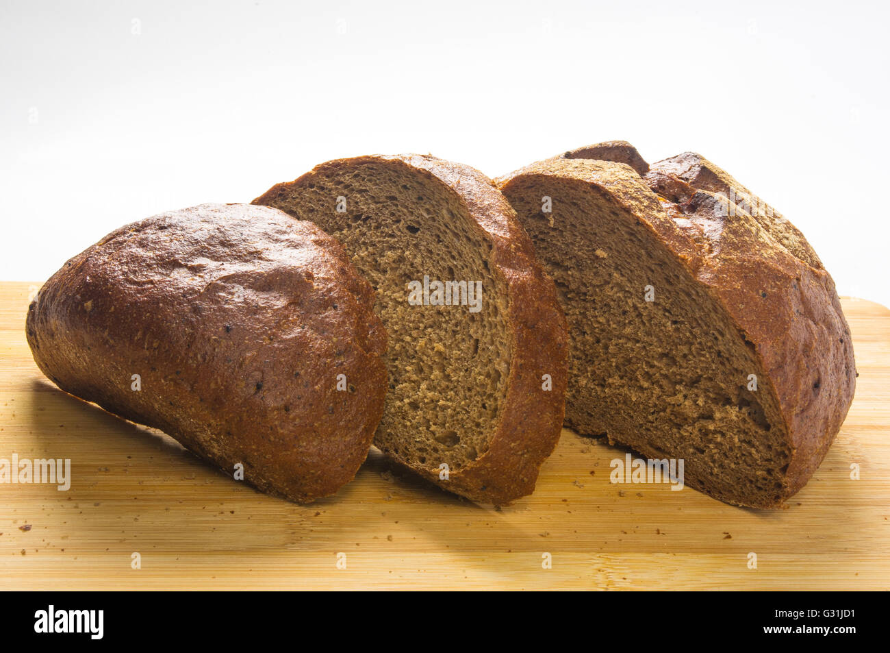 Sliced dark bread with crumbs on wood board Stock Photo - Alamy