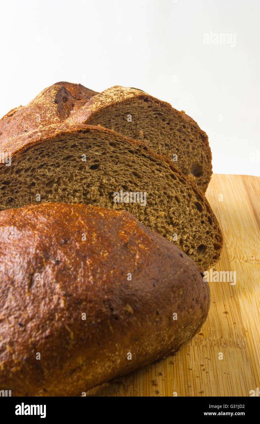 Sliced dark bread with crumbs on wood board Stock Photo - Alamy