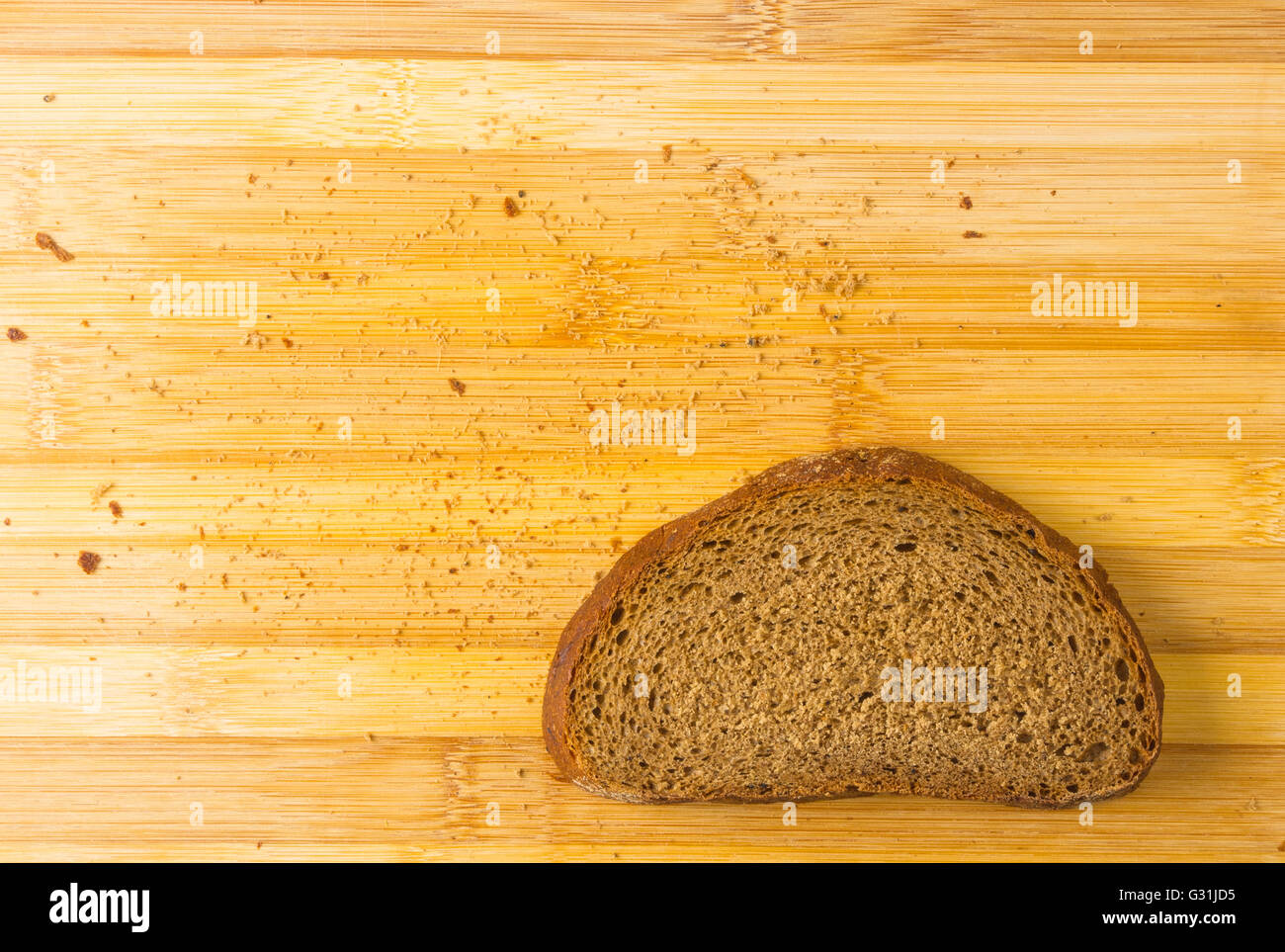 Sliced dark bread with crumbs on wood board Stock Photo - Alamy