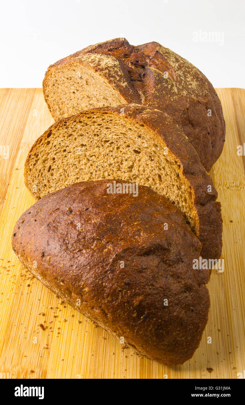 Sliced dark bread with crumbs on wood board Stock Photo - Alamy