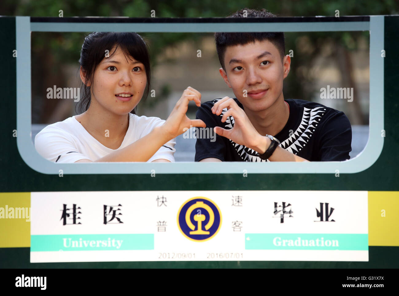 Guilin. 6th June, 2016. Graduates pose for photos behind a train model ...