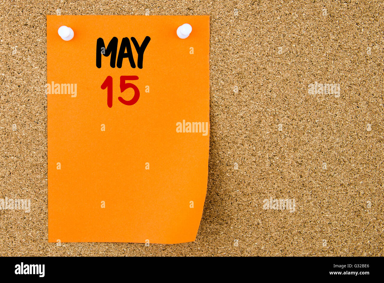 15 MAY written on orange paper note pinned on cork board with white ...